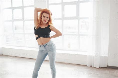 Front View Attractive Redhead Woman Posing In The Spacey Room Near The Window 8681480 Stock