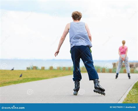 Mann Der Hinter Frau Auf Promenade Rollerblading Ist Stockbild Bild