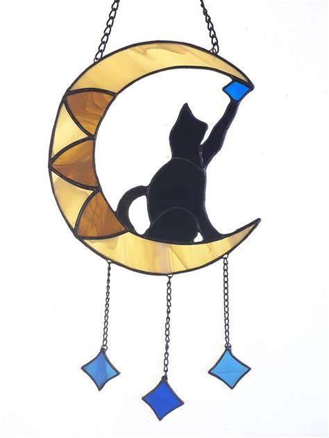 A Stained Glass Cat Sitting On The Moon With Its Paw In It S Hand