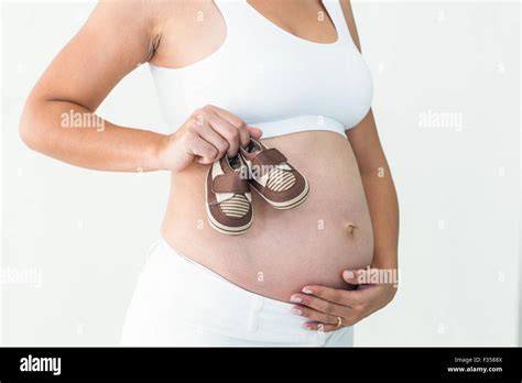 Pregnant Woman Holding Baby Shoes Stock Photo Alamy