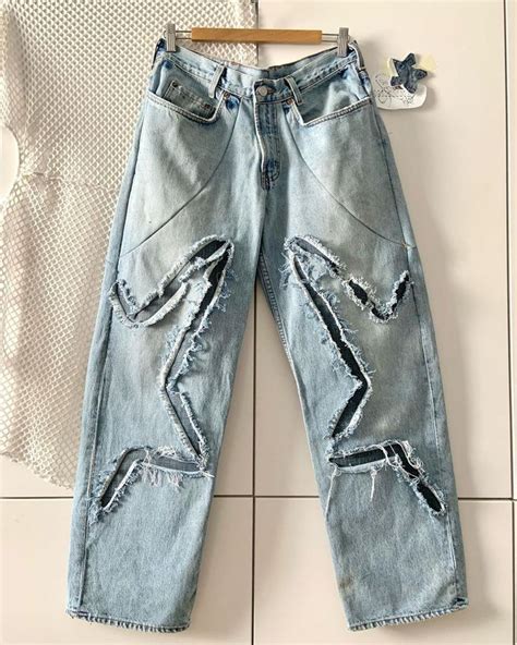 A Pair Of Ripped Jeans With Holes On The Bottom And Side Hanging From