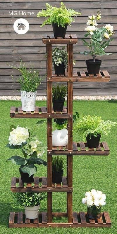 A Wooden Shelf Filled With Potted Plants On Top Of Grass
