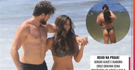 Isadora Cruz de biquíni e Sergio Guizé se beijam em gravação na praia
