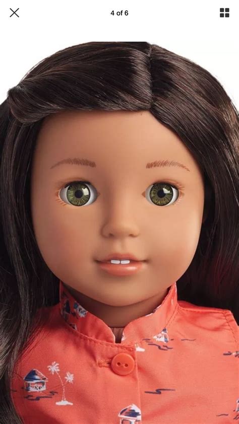 A Close Up Of A Doll With Brown Hair And Green Eyes Wearing An Orange Shirt
