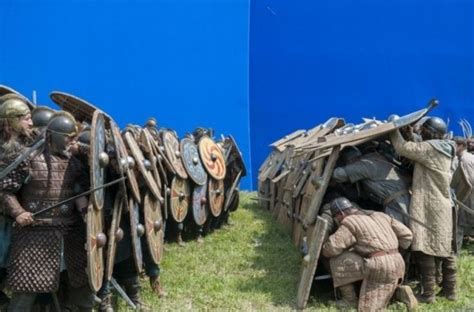 Several Men In Armor Are Standing Next To Each Other With Shields And