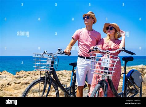 happy adult people cheerful couple enjoy the outdoor leisure activity riding a bike seaside
