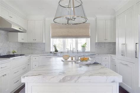 White Kitchen Features White Cabinets Paired With Gray And White Marble