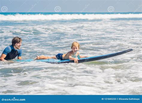 Engendre Enseñando a Su Hijo Joven a Cómo Practicar Surf En El Mar El