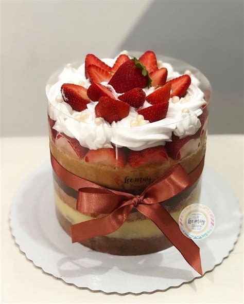A Cake With Strawberries And Whipped Cream On Top Is Sitting On A Gold