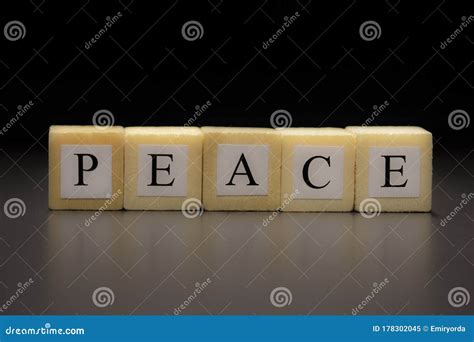 The Word Peace Written On Wooden Cubes Isolated On A Black Background