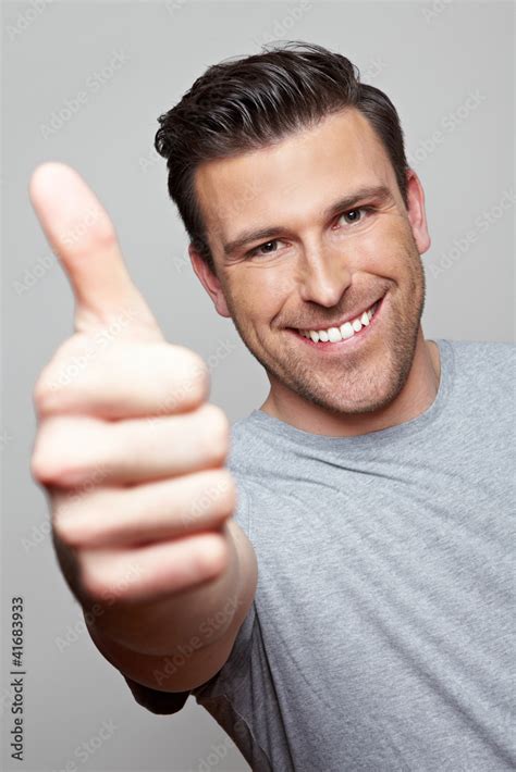 Lachender Mann hält Daumen hoch foto de Stock Adobe Stock