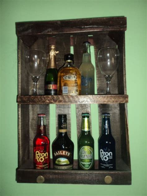 An Old Wooden Shelf With Bottles And Wine Glasses On It In Front Of A