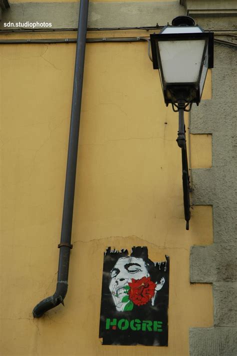 A Sign On The Side Of A Building That Says Horore With A Rose Painted On It