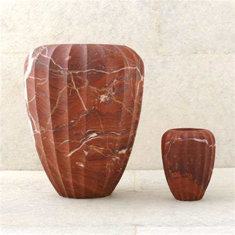 Two Red Vases Sitting Next To Each Other On A White Surface