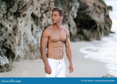 Homme Sexy Sportif Musculaire Dans Le Pantalon Blanc Avec Un Torse Nu