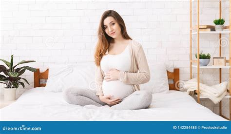 Embarazo Enjoting De La Mujer Embarazada En Su Dormitorio Imagen De