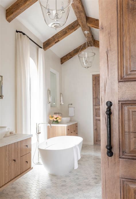 A Large White Bath Tub Sitting Inside Of A Bathroom Next To A Wooden