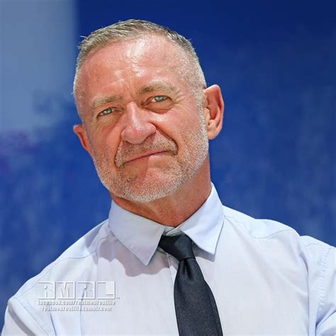 An Older Man Wearing A White Shirt And Black Tie