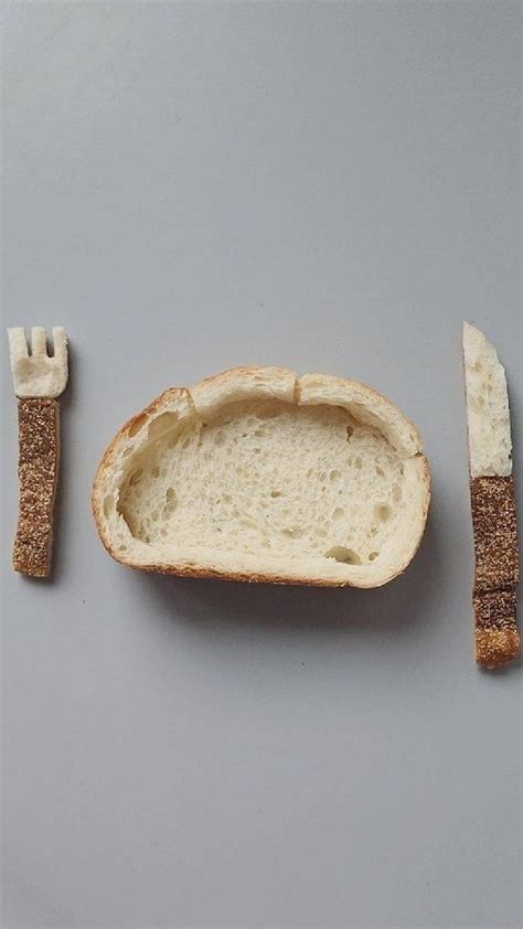 A Piece Of Bread With A Fork And Knife Next To It On A Gray Surface