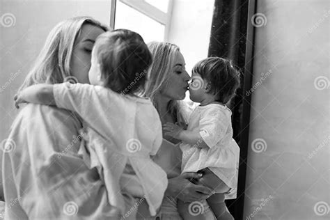 A Mother Stands At The Mirror With Her One Year Old Daughter In Her Arms The Mother Hugs And