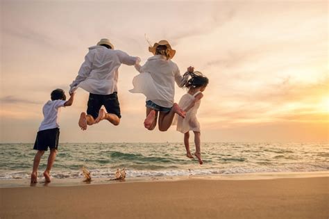 Glückliche Familie hat Spaß beim Springen am Strand im Urlaub bei