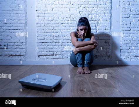 Joven adolescente bulímica anoréxica mujer sentada sola en el suelo
