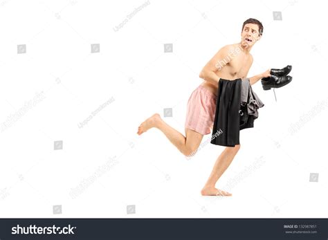 An Embarrassed Naked Man In Underwear Holding His Clothes And Running