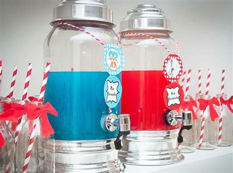 There Are Many Glass Jars With Red White And Blue Drinks In Them