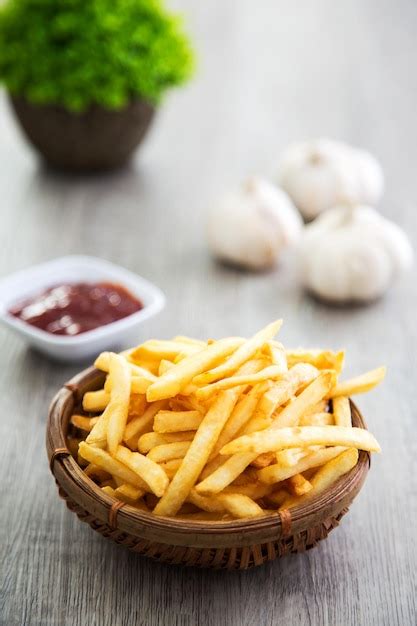 Um Balde De Batatas Fritas Na Mesa De Madeira Foto Premium