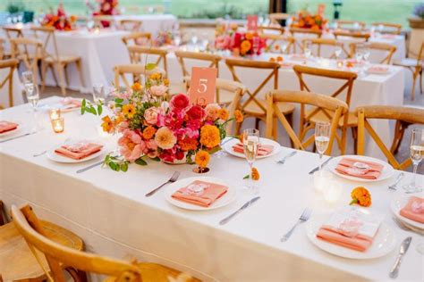 The Table Is Set With Pink And Orange Flowers