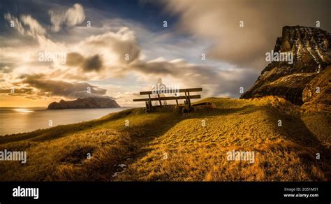 Bench On Cliff At Sunset And Mykines Island In Background Faroe