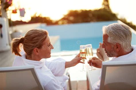 The Best Couples Getaway Rearview Shot Of A Mature Couple Drinking Champagne While Relaxing In