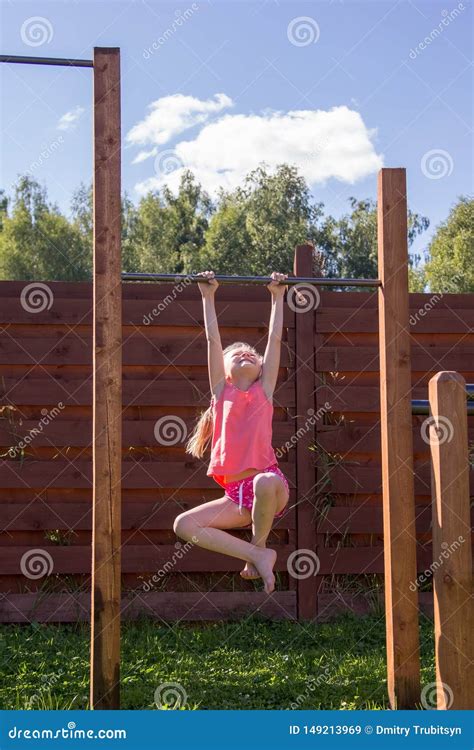 Kleines M Dchen Das An Der Horizontalen Stange H Ngt Stockbild Bild