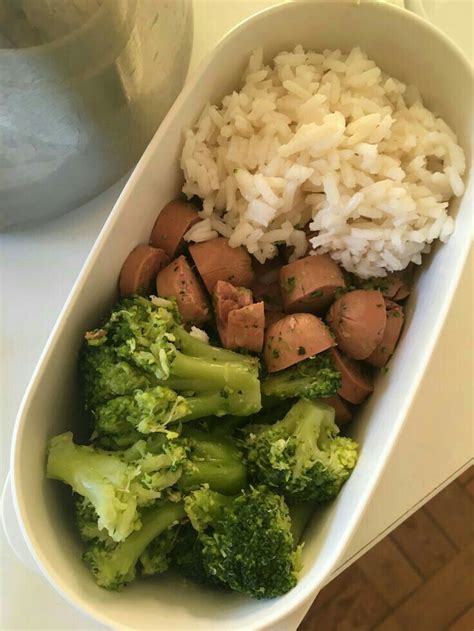 A White Bowl Filled With Rice Broccoli And Meat