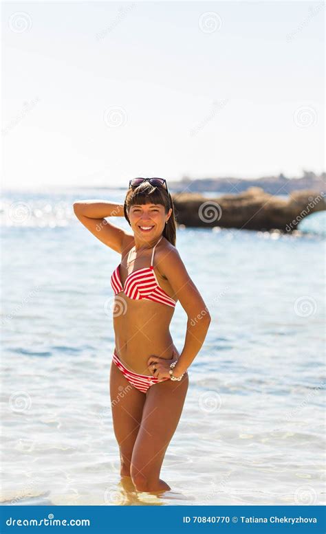 Jeune Belle Fille Dans Le Bikini De Maillot De Bain Posant Sur La Plage