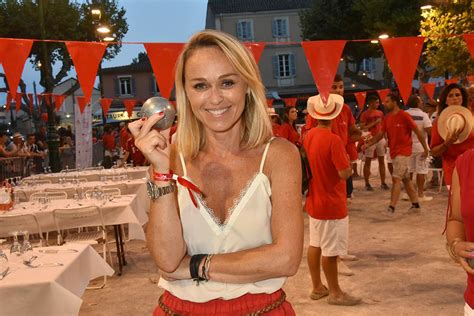 A Woman In A Red And White Outfit Holding A Silver Object At An Outdoor