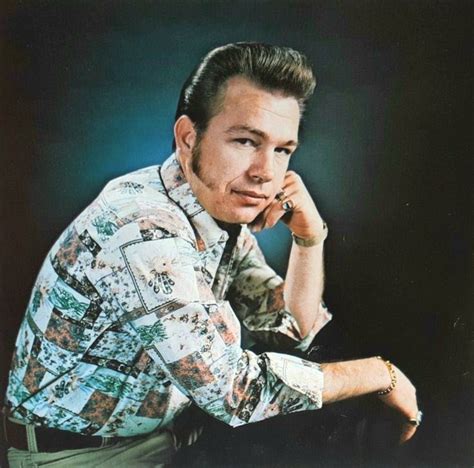 A Man Sitting Down With His Hand On His Chin And Looking At The Camera