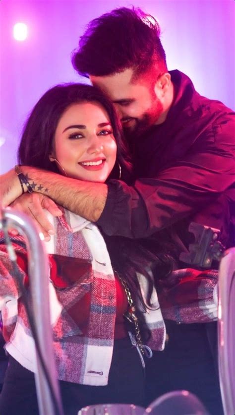 A Man And Woman Embracing Each Other In Front Of Purple Lights