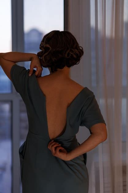 Hermosa Chica Desnuda Se Abrocha El Vestido Azul En La Espalda Foto