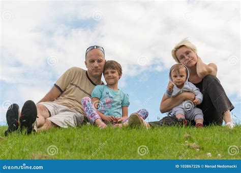 Famille Heureux S Asseyant Sur L Herbe Photo Stock Image Du