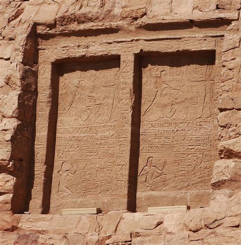 An Ancient Window With Carvings On The Side Of It In A Stone Building
