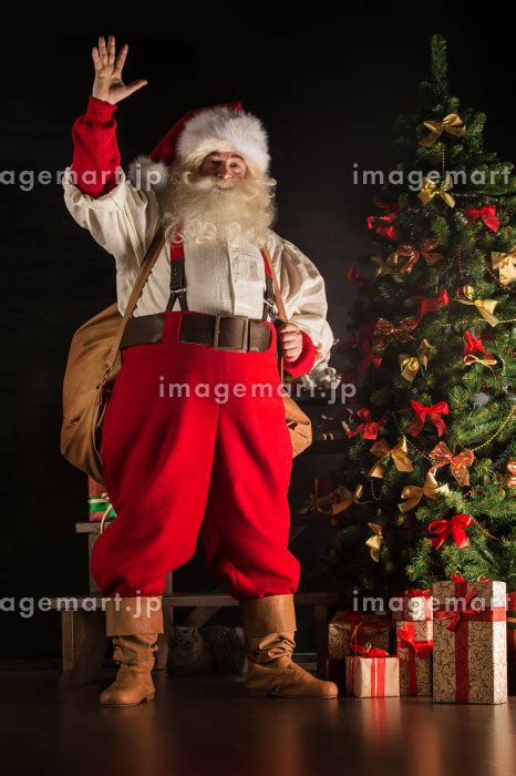 Full Length Portrait Of Real Santa Claus Carrying Big Bag Full Of Gifts