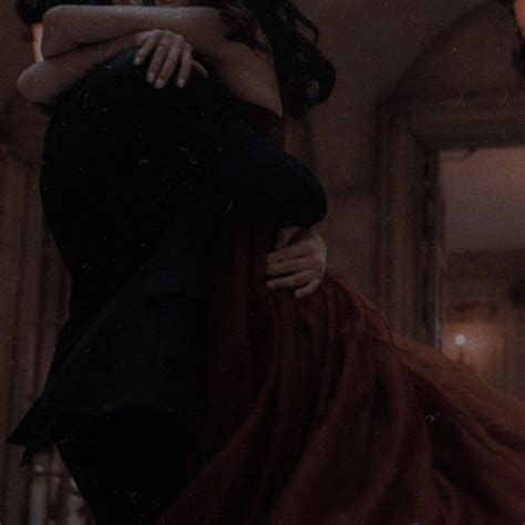 A Woman Is Hugging Another Woman With Her Arms Around Her