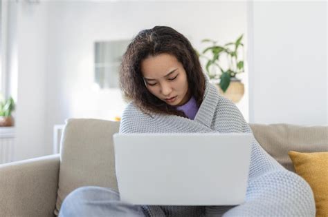 Premium Photo Asian Woman Wrapped In A Cozy Blanket Sitting On The Sofa And Working On Her Laptop