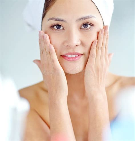 Silky Smooth Skin An Attactive Young Asian Woman Applying Moisturizer With A Towel On Her Head