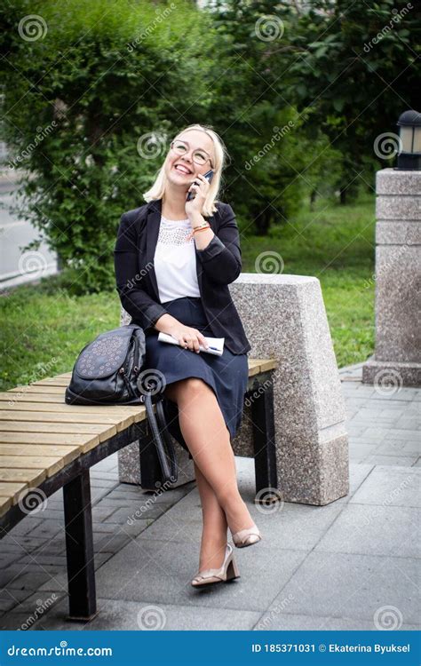 Young Beautiful Blonde In Glasses Talking On A Smartphone And Laughing Business Woman On The