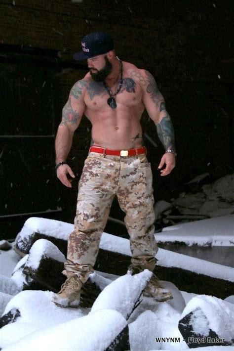 A Shirtless Man Standing On Top Of Snow Covered Rocks