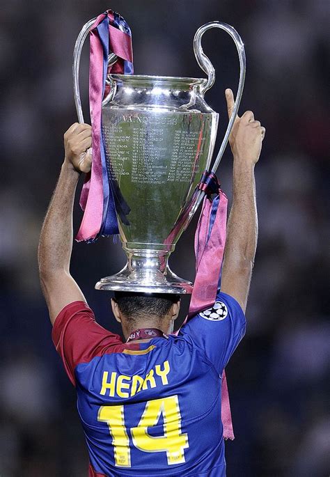 A Man Holding Up A Silver Trophy On Top Of His Head