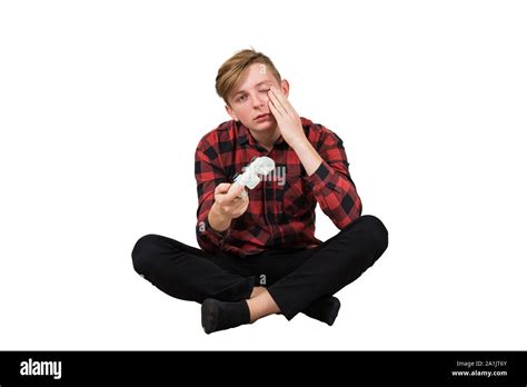 Tired Teenage Guy Seated On The Floor Playing Video Games Isolated Over White Background Sleepy