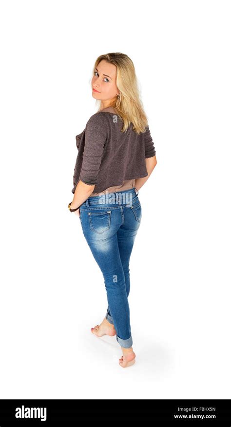 Young Attractive Woman In Blue Jeans Standing From The Back And Looking Over Her Shoulder